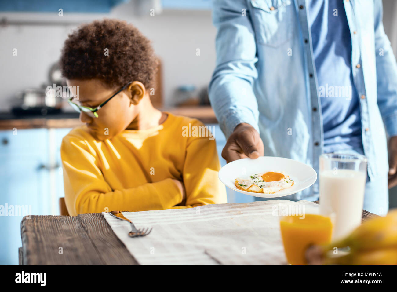 Curly-haired pre-teen boy refusing to eat fried egg Stock Photo - Alamy