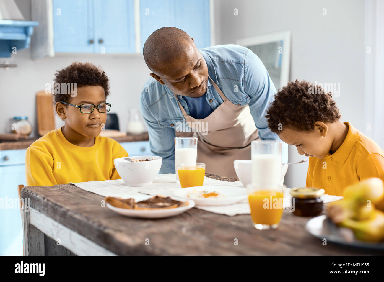 Caring father talking to his upset son at breakfast Stock Photo - Alamy