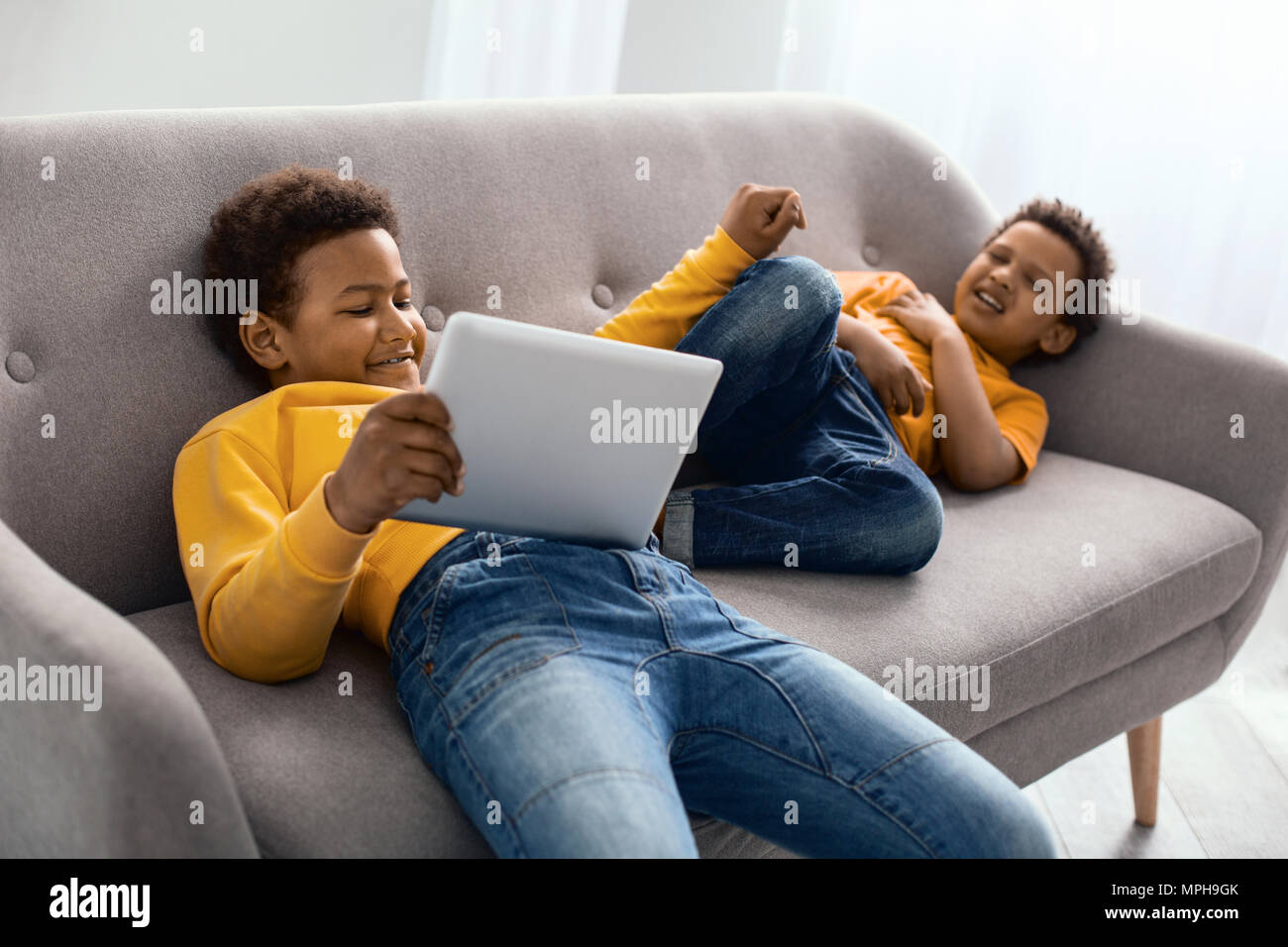 Smiling pre-teen boy pushing away his younger brother Stock Photo - Alamy