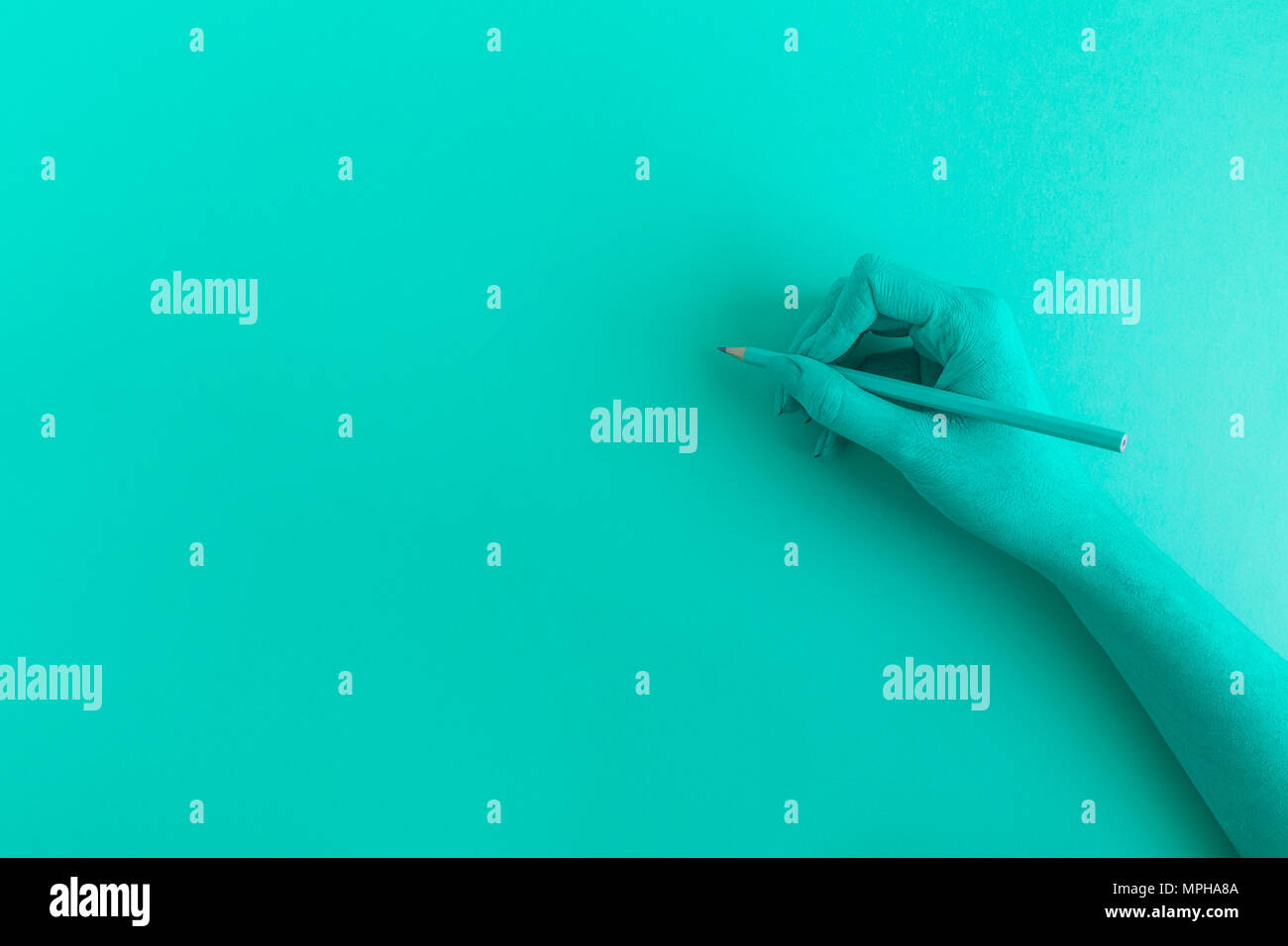 Female hand holding pencil. Turquoise color minimal creative concept ...