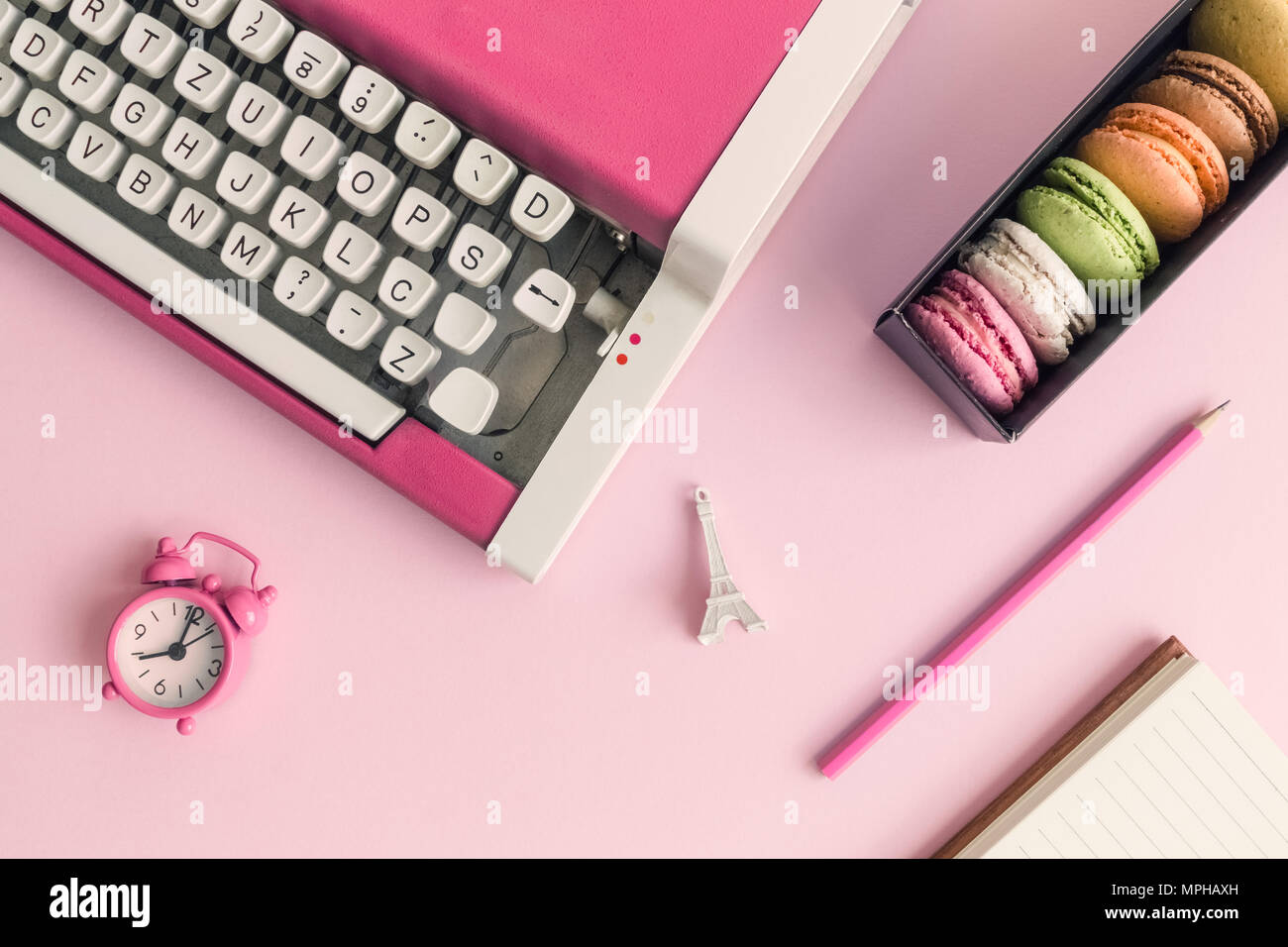 Flat lay of typewriter, macaroons, alarm clock, Eiffel Tower miniature ...