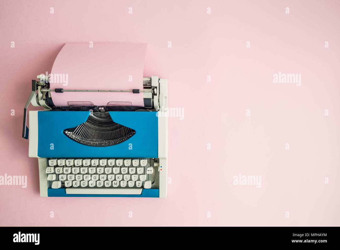 Top view of blue vintage typewriter with blank paper sheet on table ...