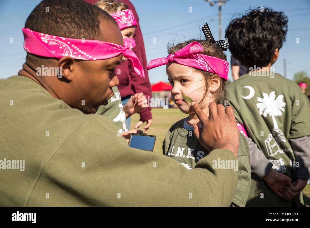 A Marine paints a child’s face during Mini Marines aboard Marine Corps ...