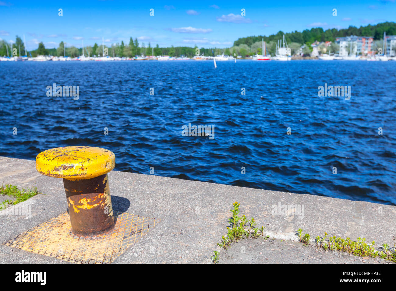 Yellow mooring bollard mounted in concrete embankment. Lappeenranta ...