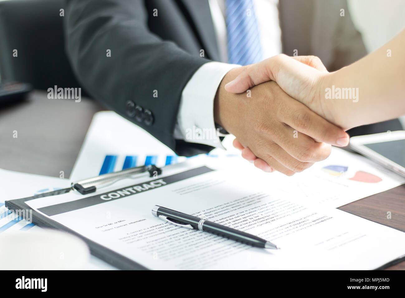 Two businessmen shaking hand after successful negotiate and signing on ...