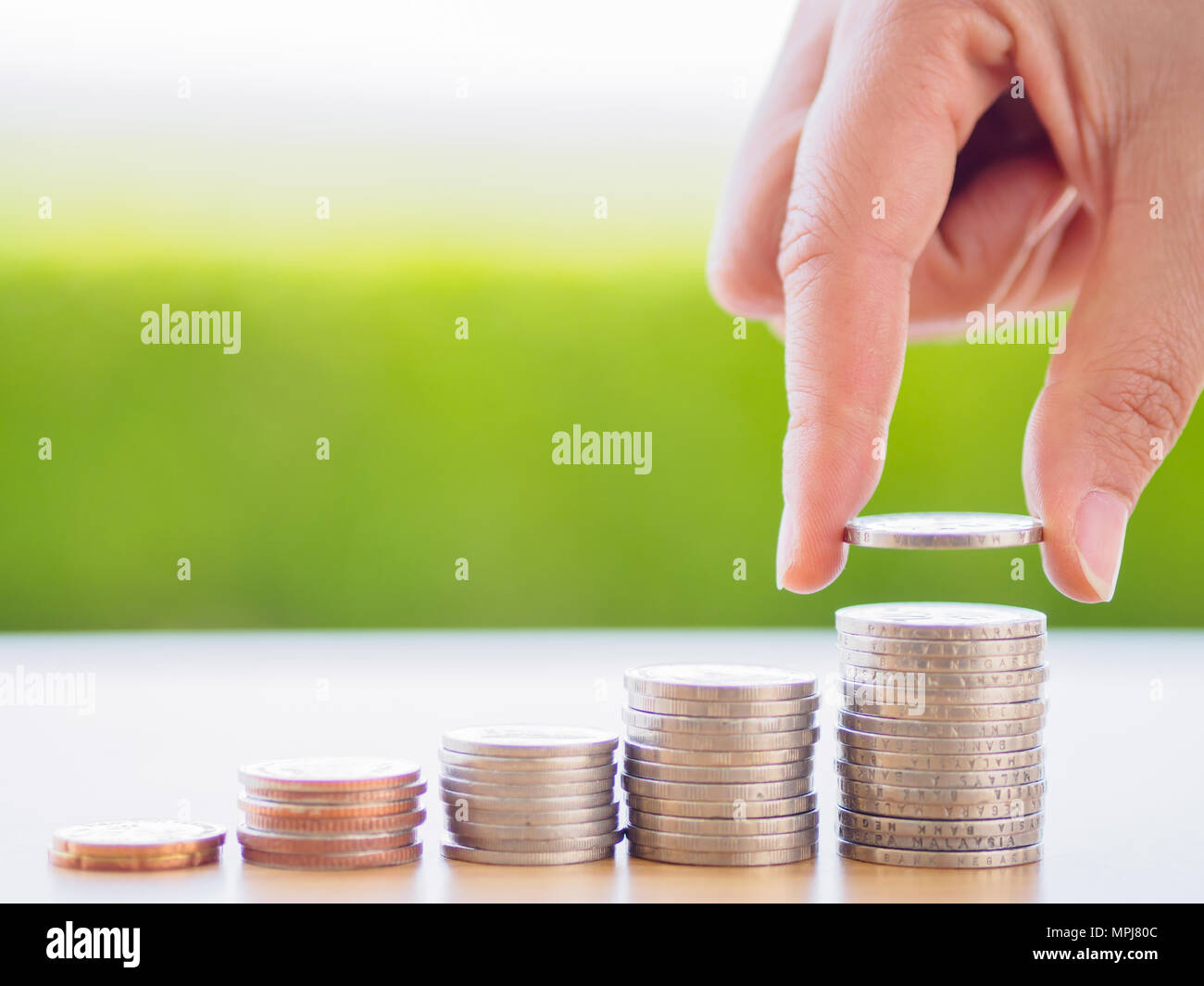 Hand put coin stacking hi-res stock photography and images - Alamy