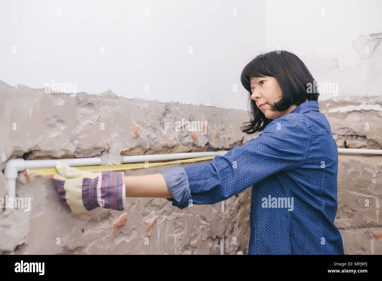 Clever woman repairing her bathroom sink pipe with positive attitude ...