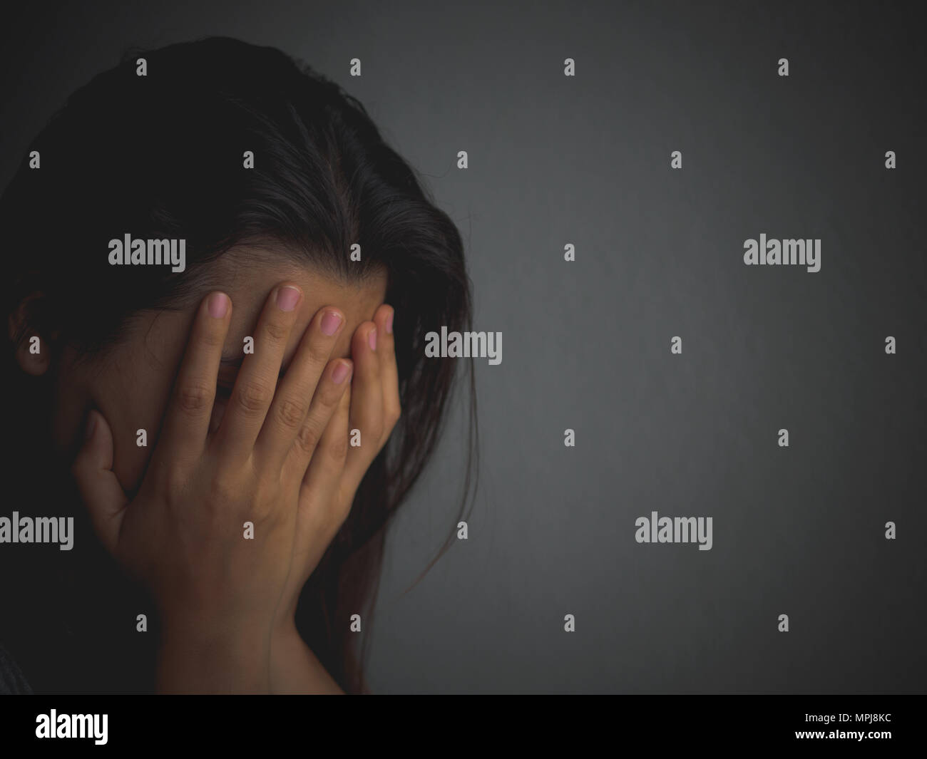 Sad woman sitting alone in a empty room Stock Photo - Alamy