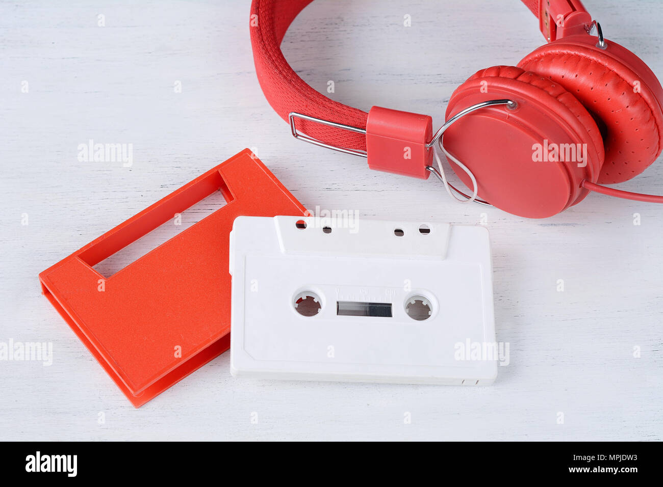 Top view of vintage headphones and audio cassette on white wooden table ...