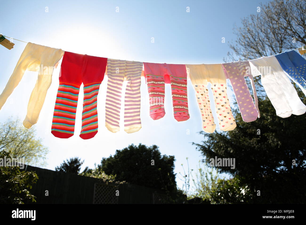 Colourful prints of baby and toddler tights hang down from the washing ...