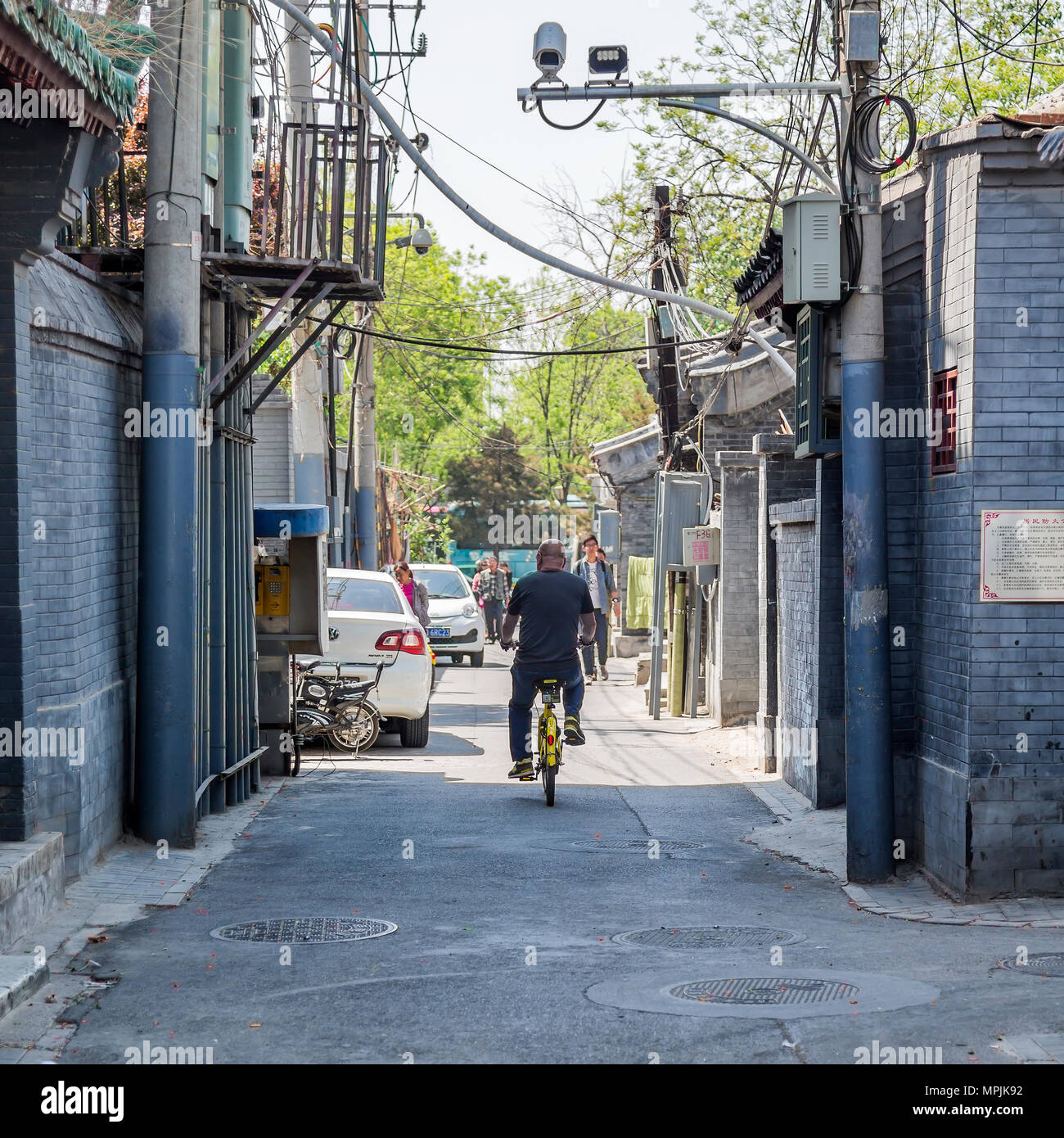 A Chinese man riding a bicycle on a backstreet in Beijing. Overlooked ...