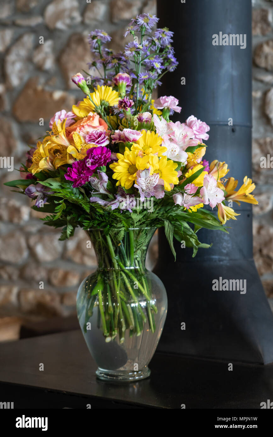 clear glass vase filled with bright colorful flowers Stock Photo - Alamy