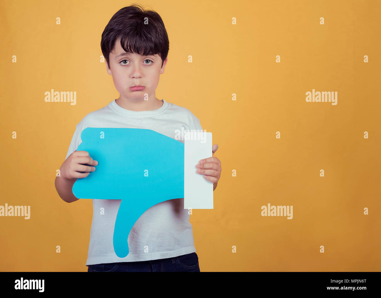 boy with a big dislike on yellow background Stock Photo - Alamy