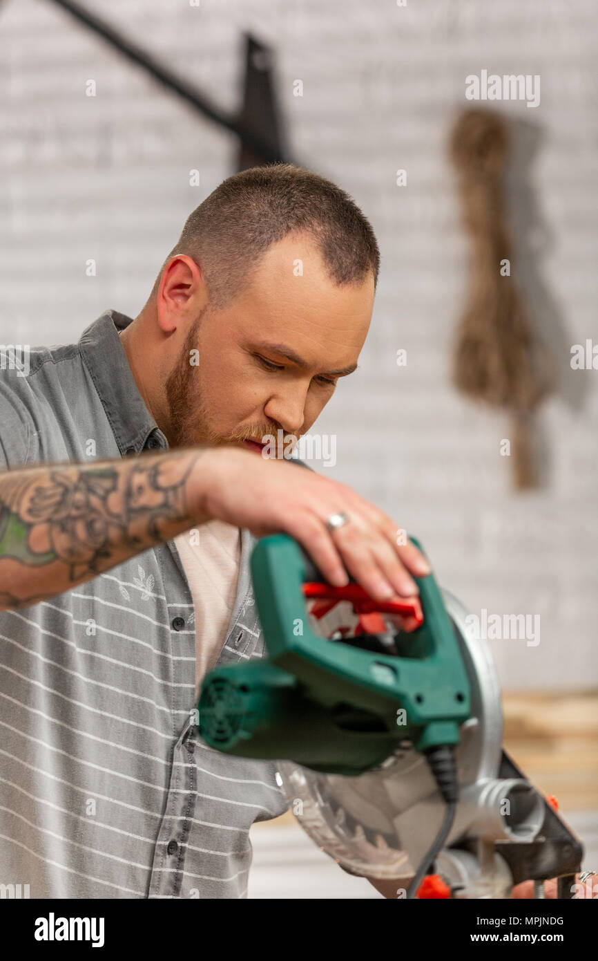 Man sawing wood with a circular saw on a workbench Stock Photo - Alamy