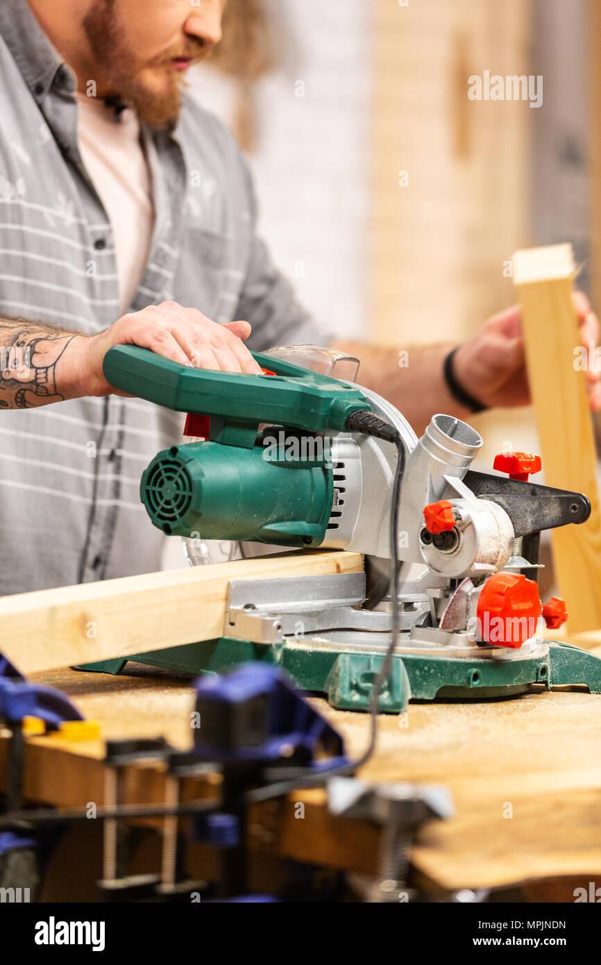 Man sawing wood with a circular saw on a workbench Stock Photo - Alamy