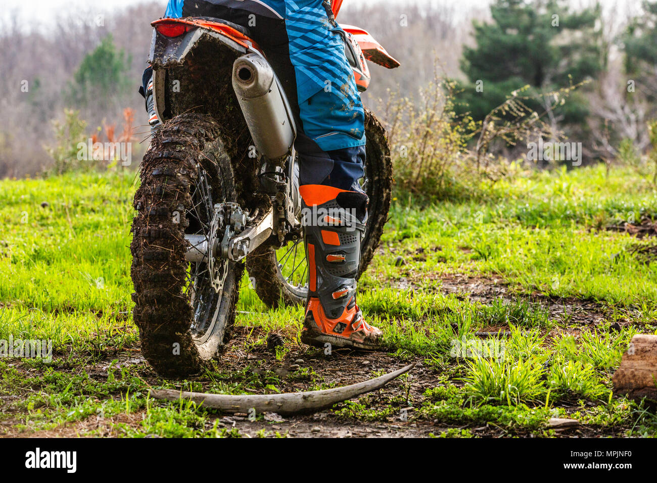 man riding a motocross in a protective suit in the mud Stock Photo - Alamy