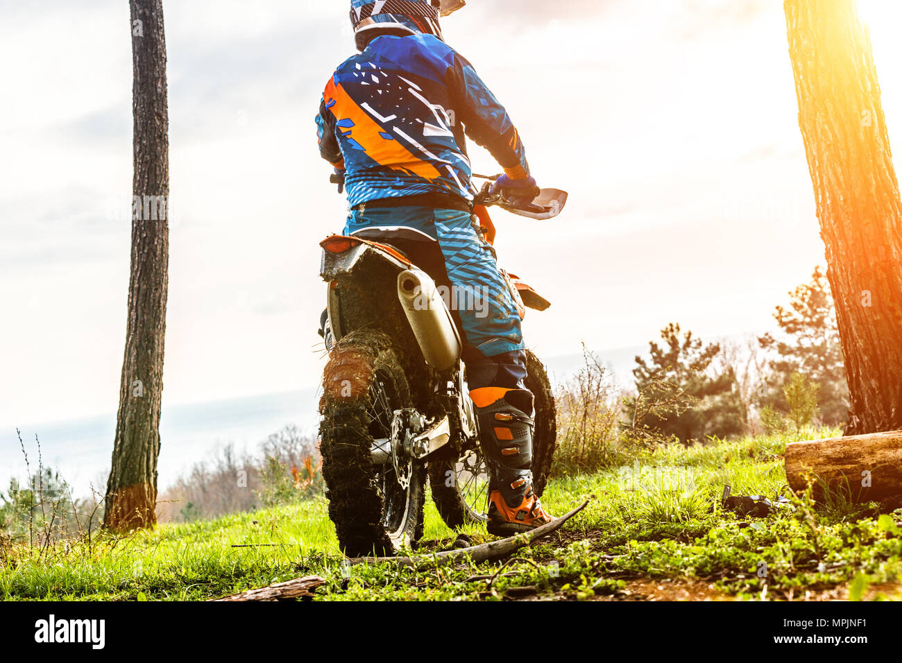 man riding a motocross in a protective suit in the mud Stock Photo - Alamy