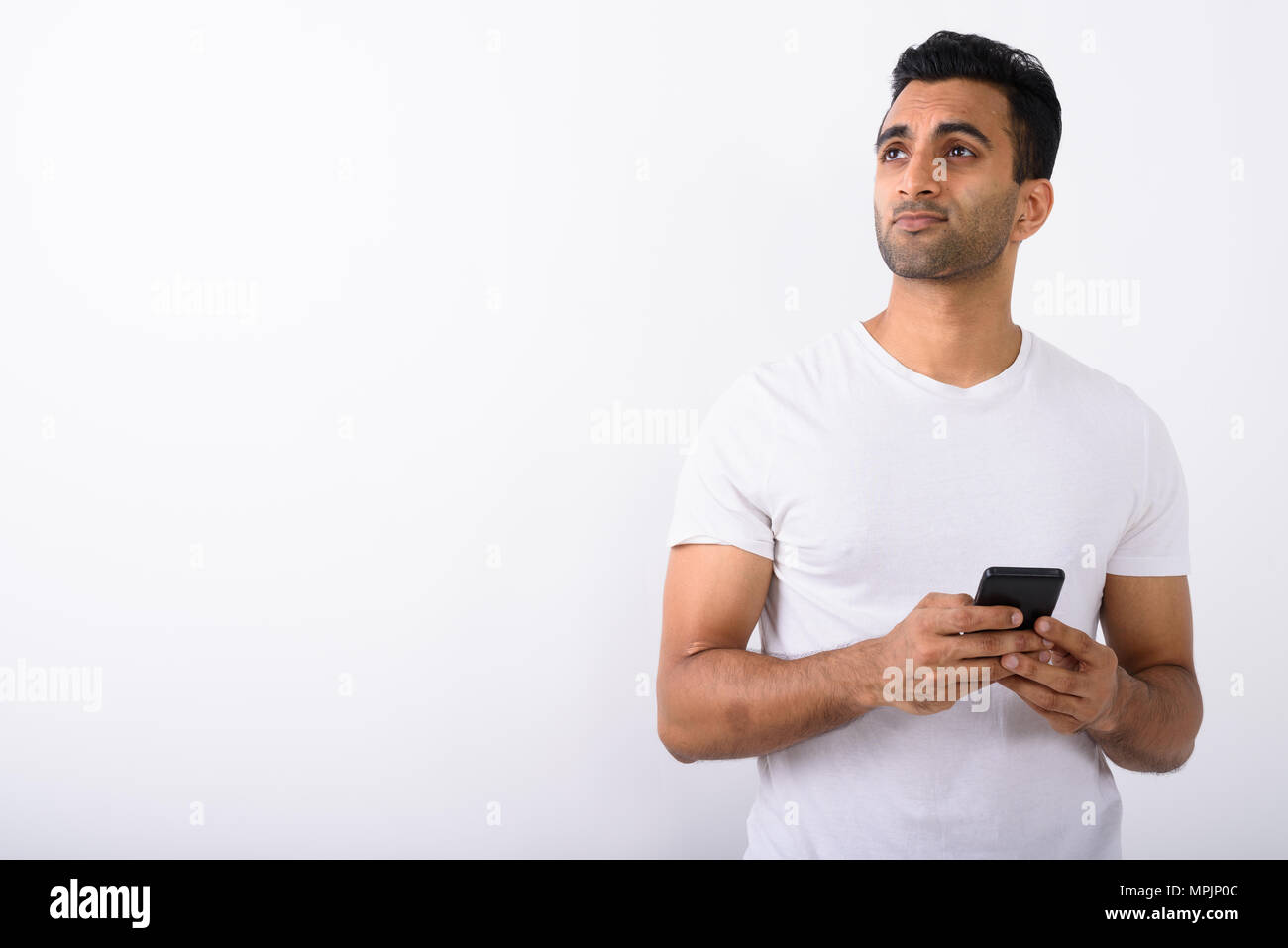Young handsome Indian man using mobile phone against white backg Stock ...