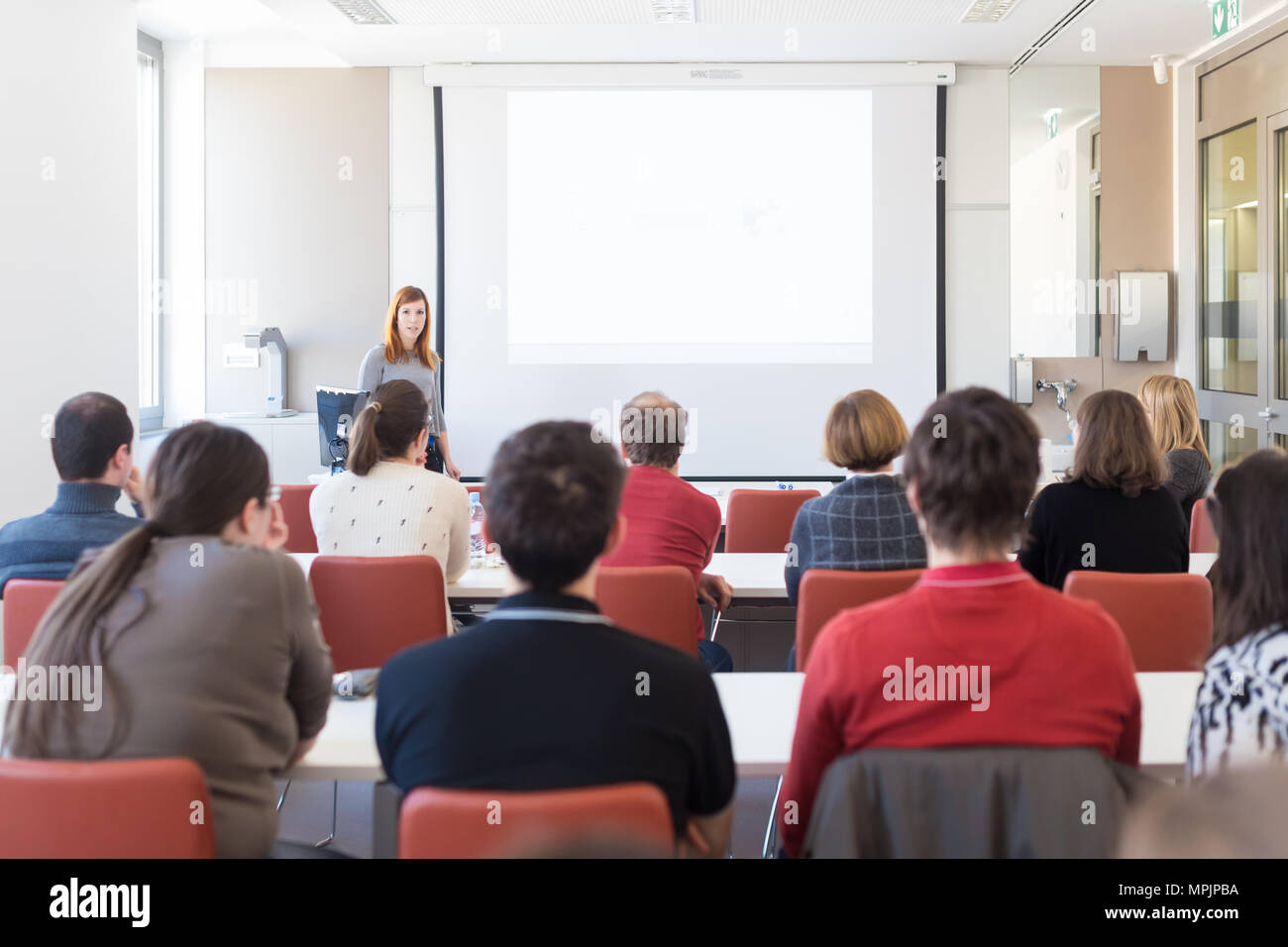 Woman giving presentation in lecture hall at university Stock Photo - Alamy