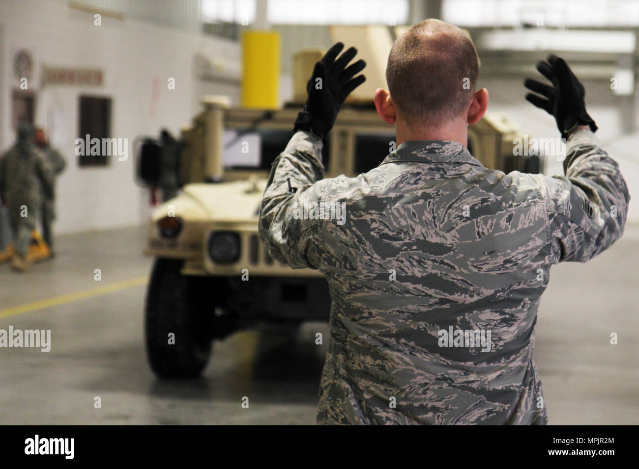 A U.S. Airmen ground guides an up-armored Humvee into position to be ...