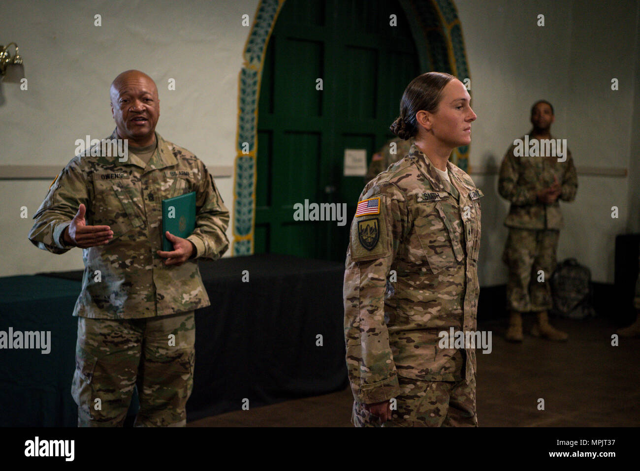 Command Sgt. Maj. Craig Owens presents Sgt. Amber Smith with an award ...