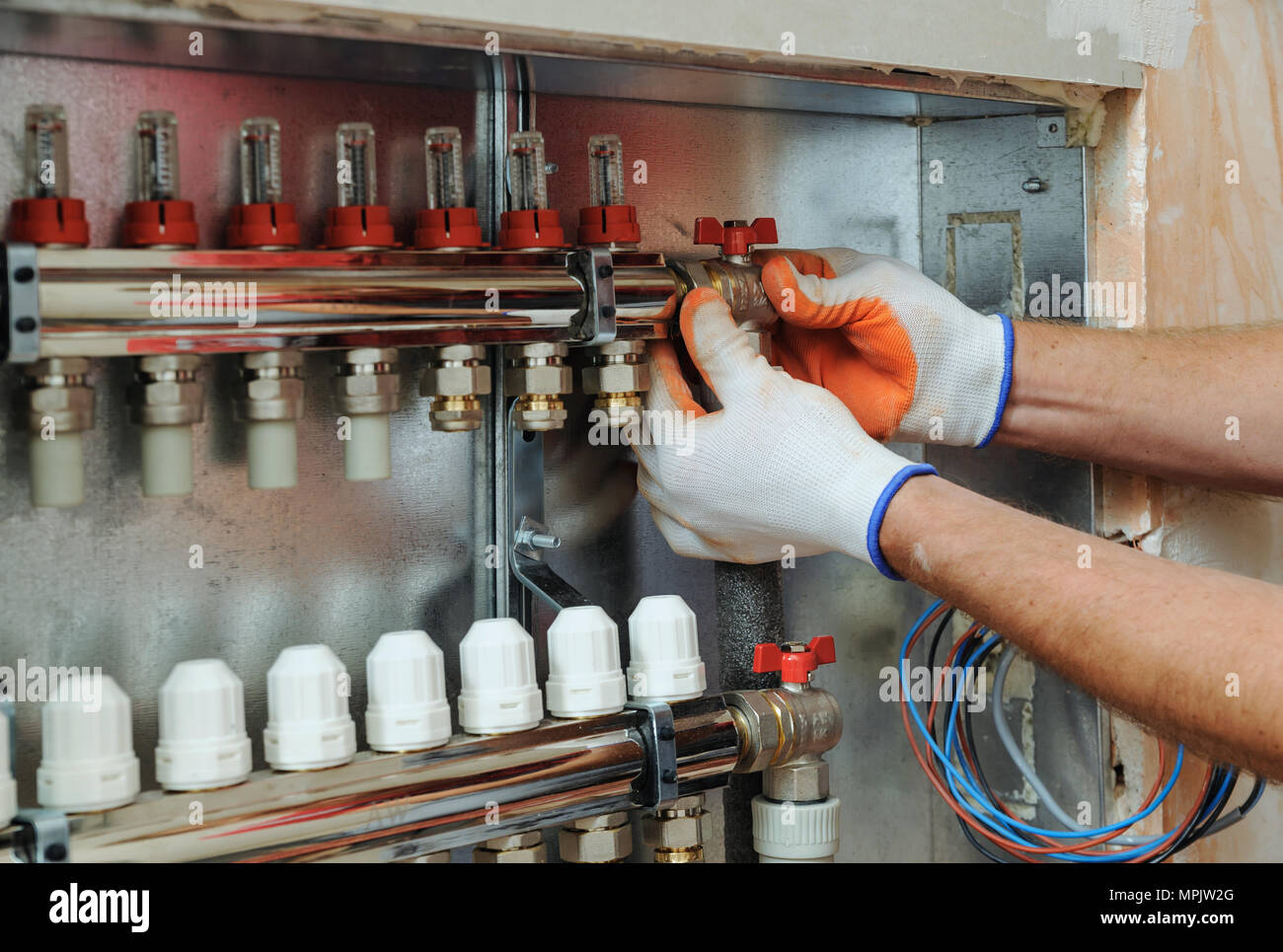 Installation of home heating. A worker attaches the tube to the ...