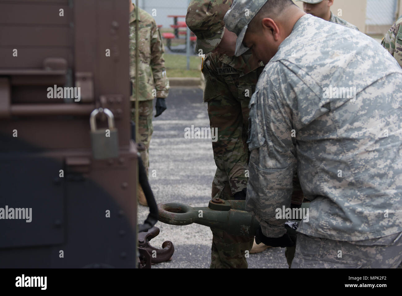 Two Soldiers from HHC 416th TEC lift and hold a tow bar, as an M1165 A1 ...