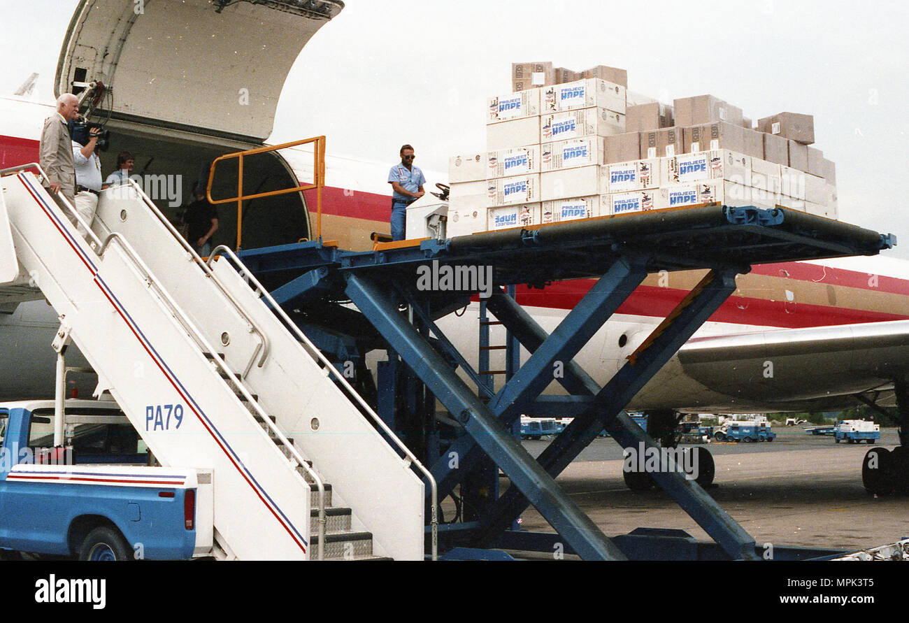 MEN LOADING PACKAGES OFF A LOADING DOCK ONTO AN AIRPLANE Stock Photo ...