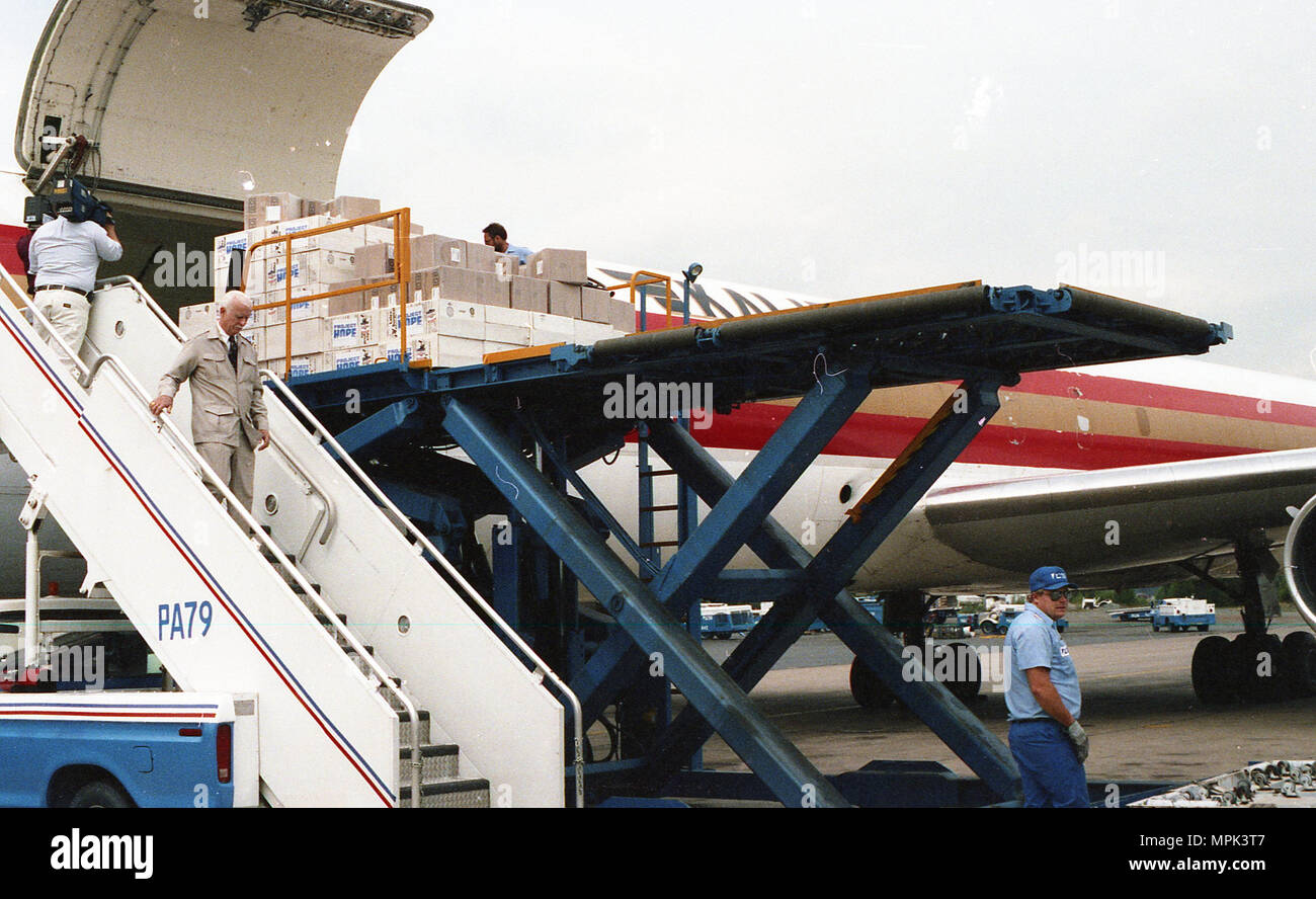 MEN LOADING PACKAGES OFF A LOADING DOCK ONTO AN AIRPLANE Stock Photo ...
