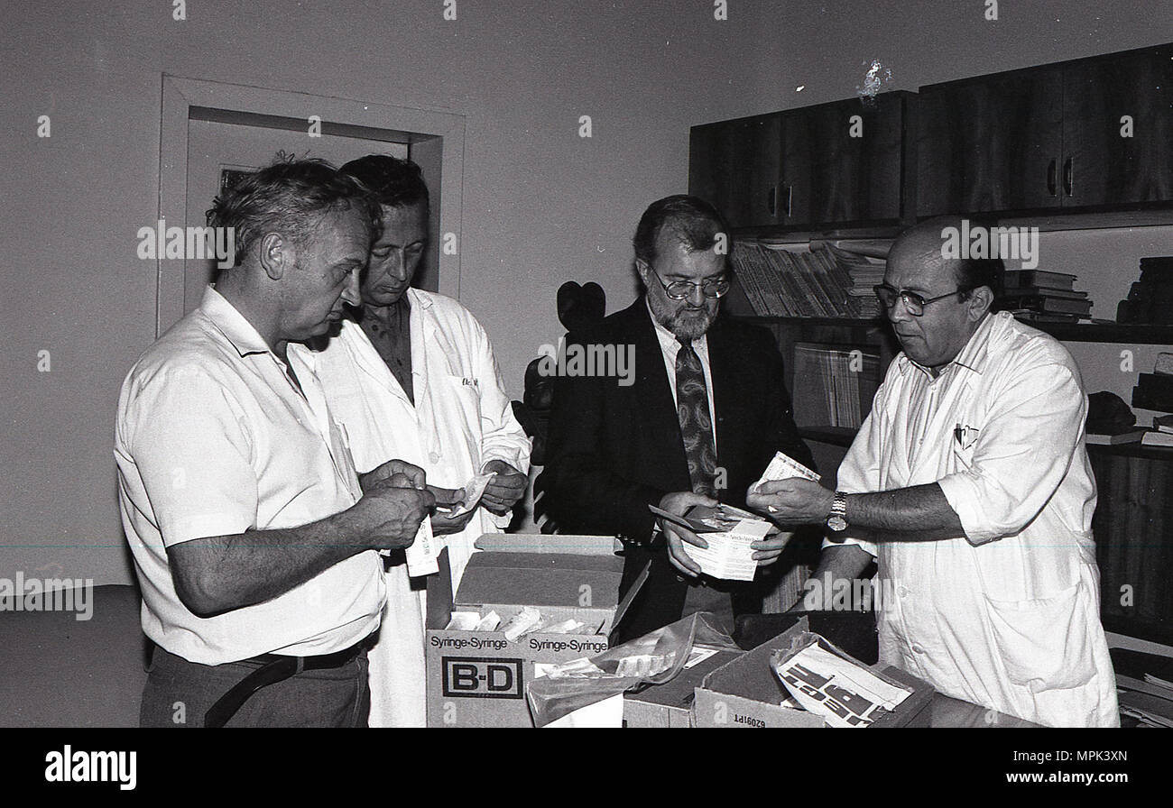 MEN OBSERVING OBJECTS IN A BOX Stock Photo - Alamy