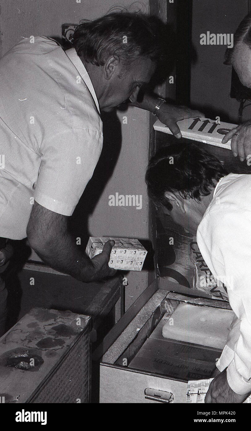 MEN INSPECTING CONTENT IN A BOX Stock Photo - Alamy