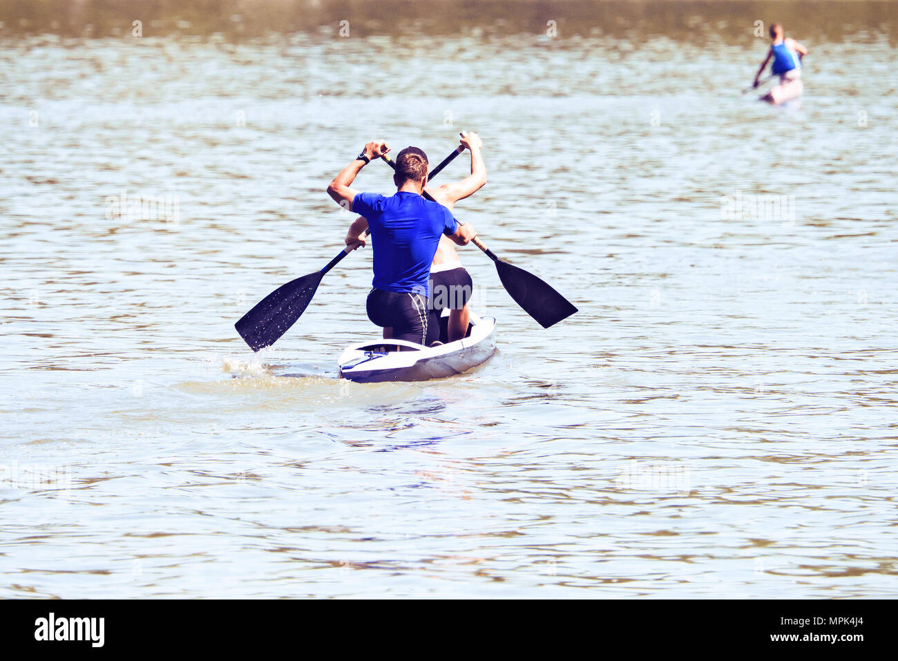 Pair of professional sportsmen swimming on kayak at competition, cross ...