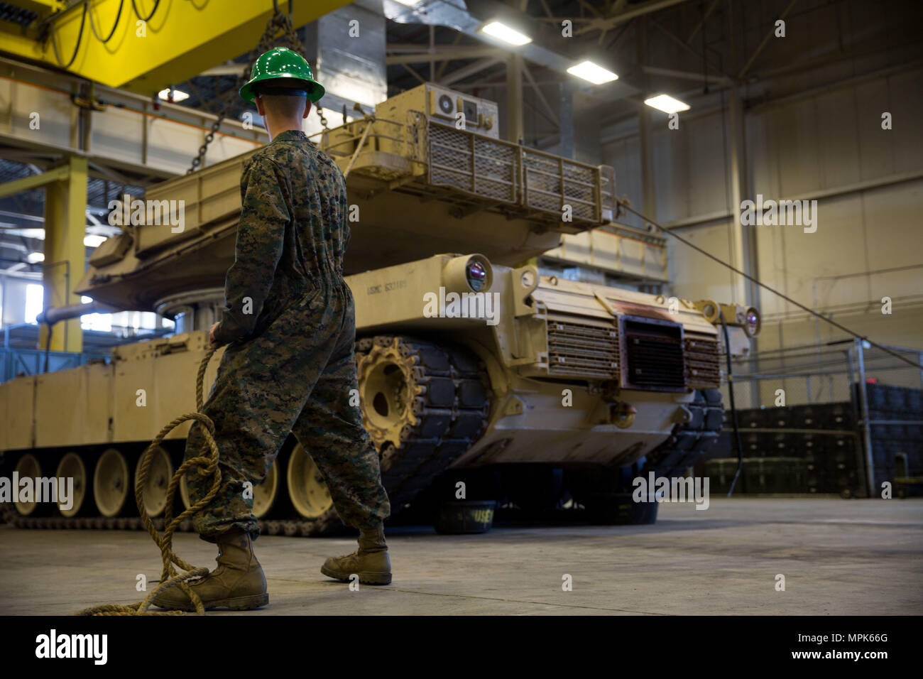A Marine holds a rope to help steady an M1A1 Abrams tank’s 120 mm ...