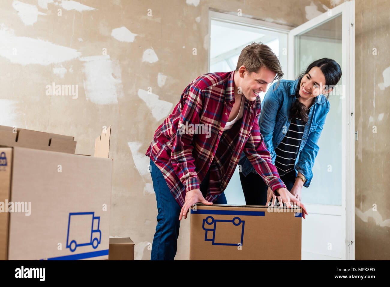 Young couple opening boxes during renovation of new home Stock Photo ...
