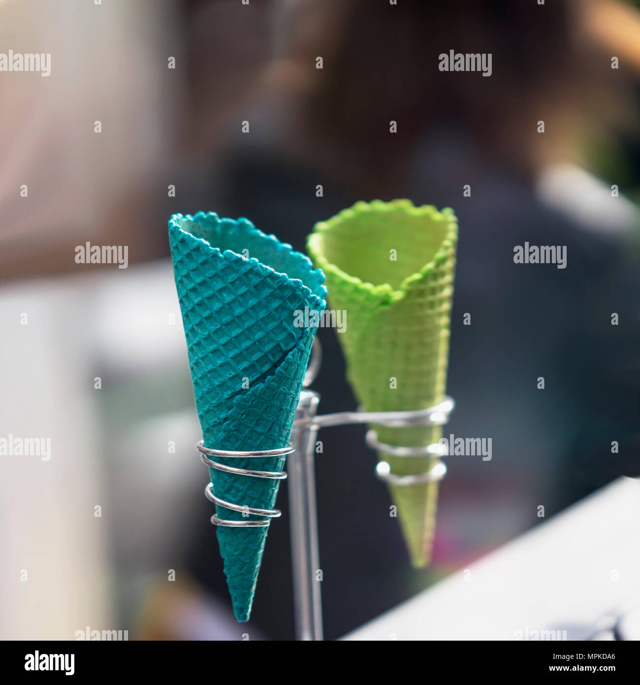 Two empty bright wafer sweet cornets for ice cream on real blurry ...