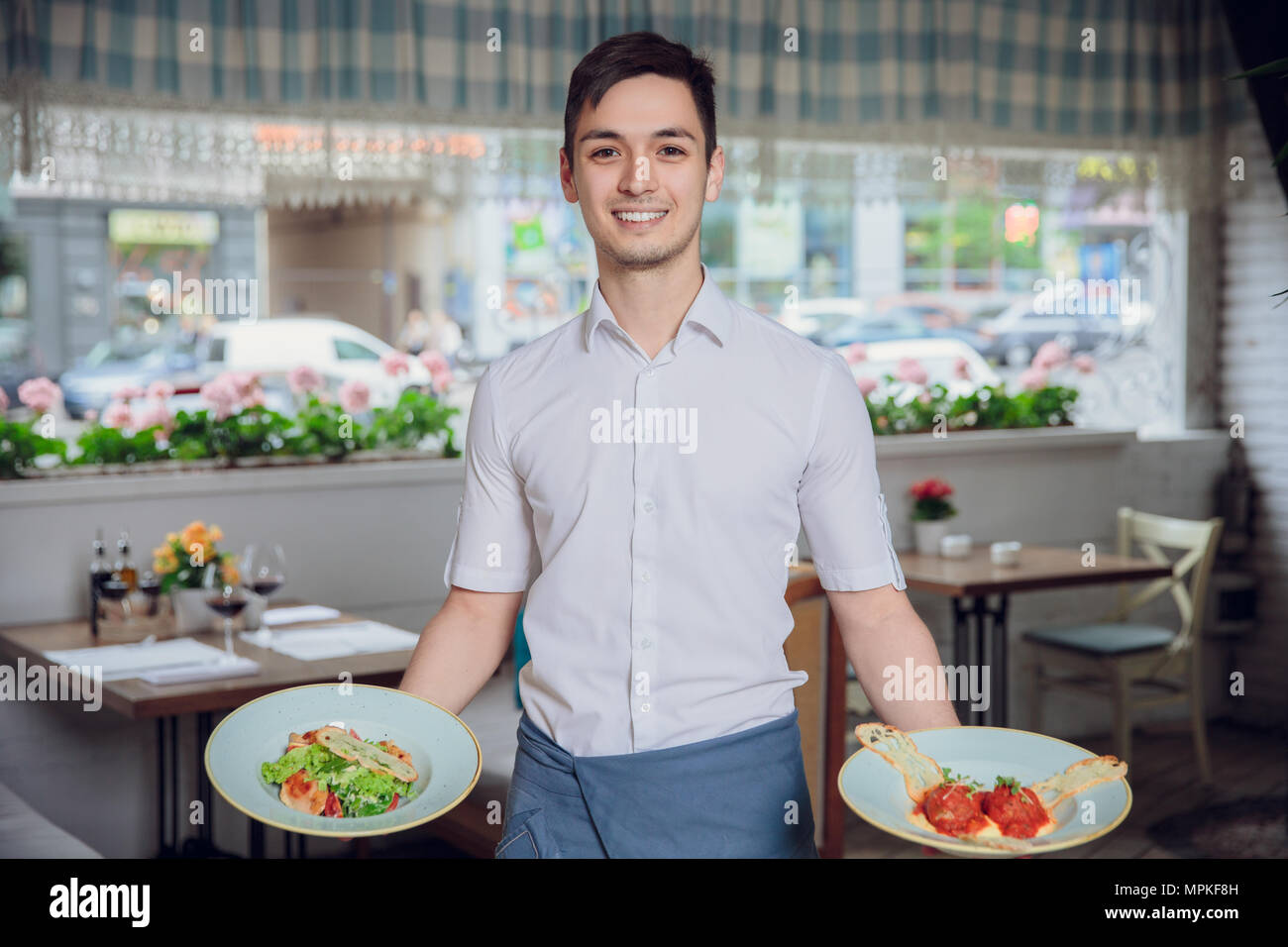Restaurant waiter carrying plates food hi-res stock photography and ...