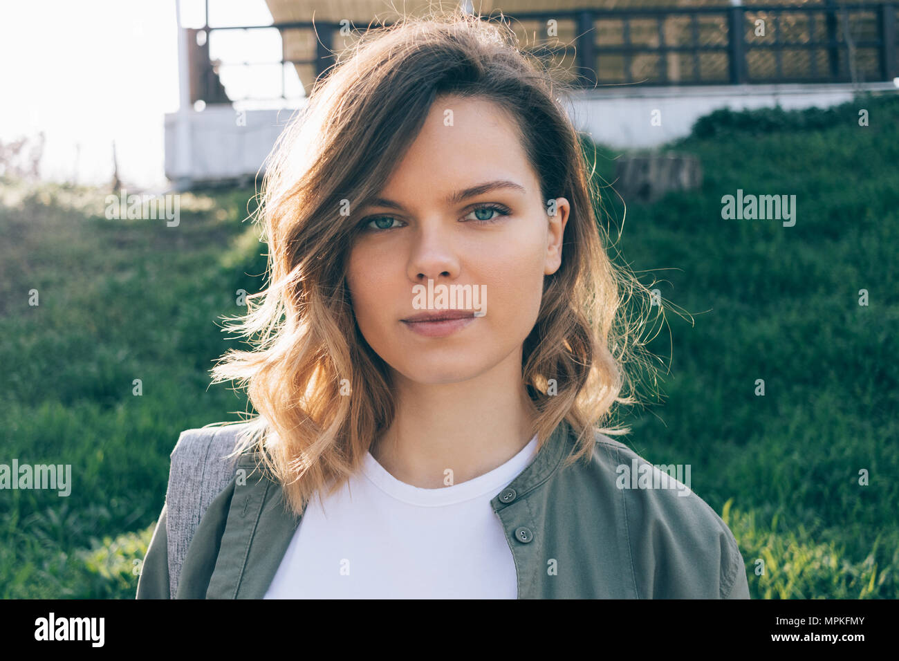 Portrait of smiling female on green grass background. Young woman with ...