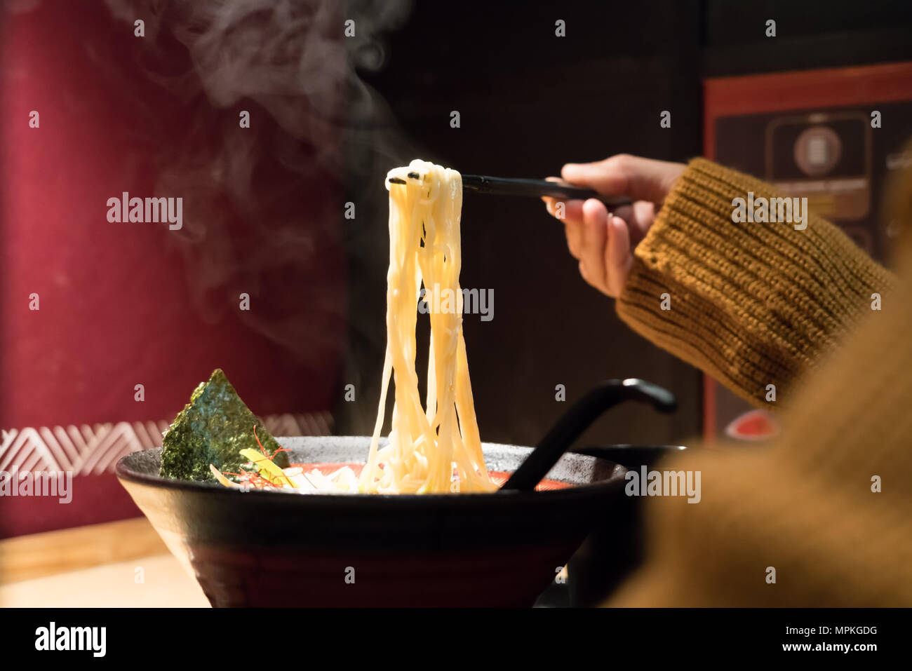 noodle ramen on chopstick hold on women hand, food and drink concept ...