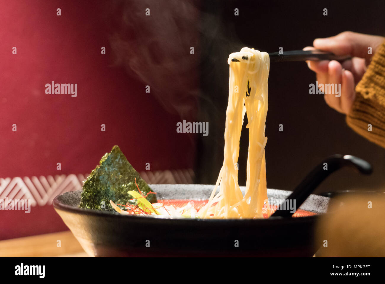 noodle ramen on chopstick hold on women hand, food and drink concept ...
