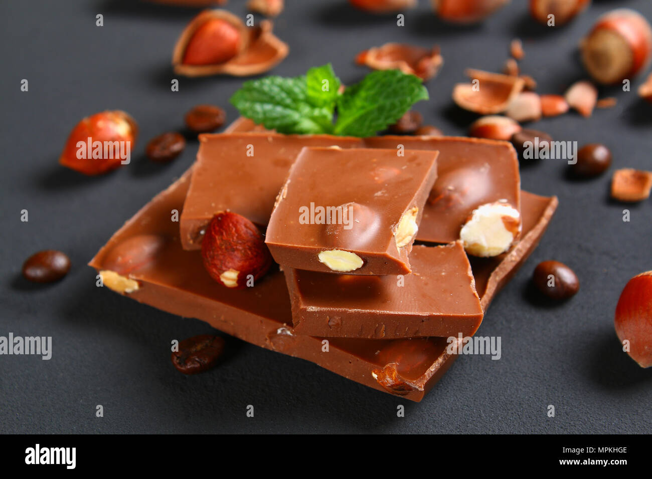 Chocolate with hazelnuts, mint and grains of coffee on a dark gray ...
