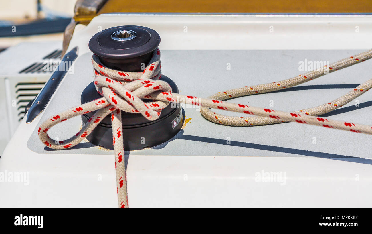 Lines attached to winch holds sailboat in slip at marina Stock Photo ...