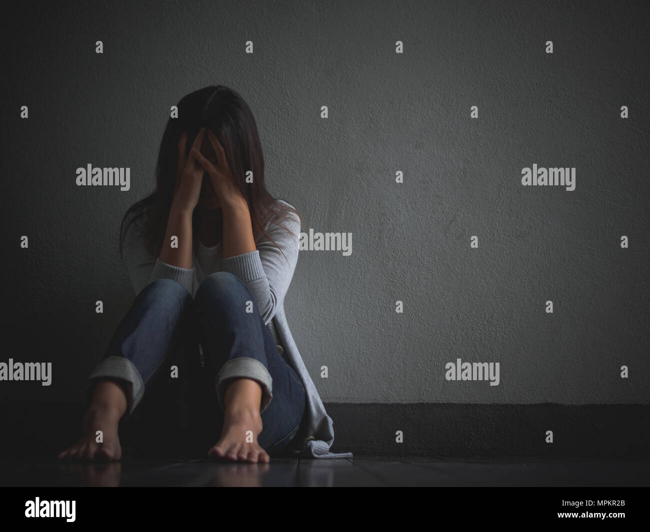 sad woman hug her knee and cry. Sad woman sitting alone in a empty room ...