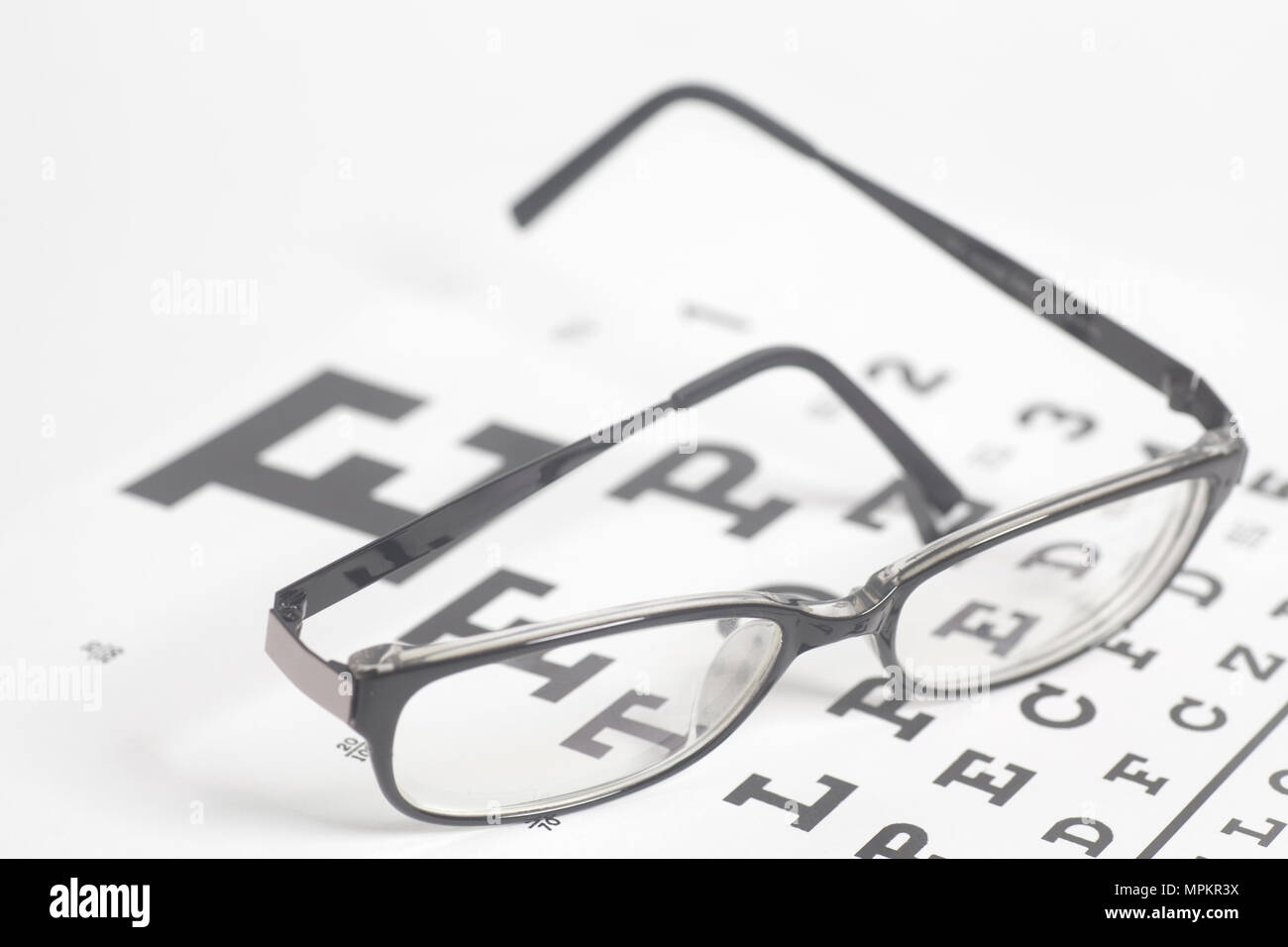 Eyeglasses on eyesight test chart background close-up Stock Photo - Alamy