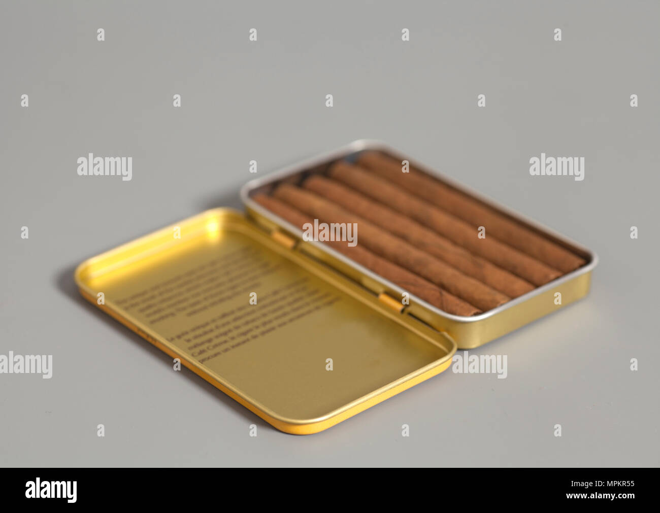 Open metal cigar box with cigars on gray background Stock Photo - Alamy
