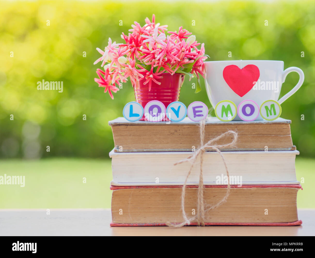 mother's day concept. LOVE MOM alphabet on stack of books, gifts, tea ...