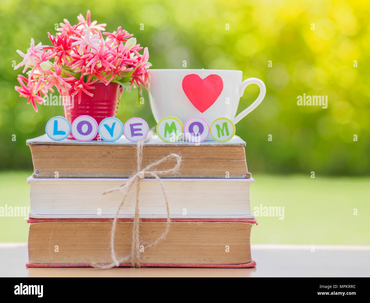 mother's day concept. LOVE MOM alphabet on stack of books, gifts, tea ...