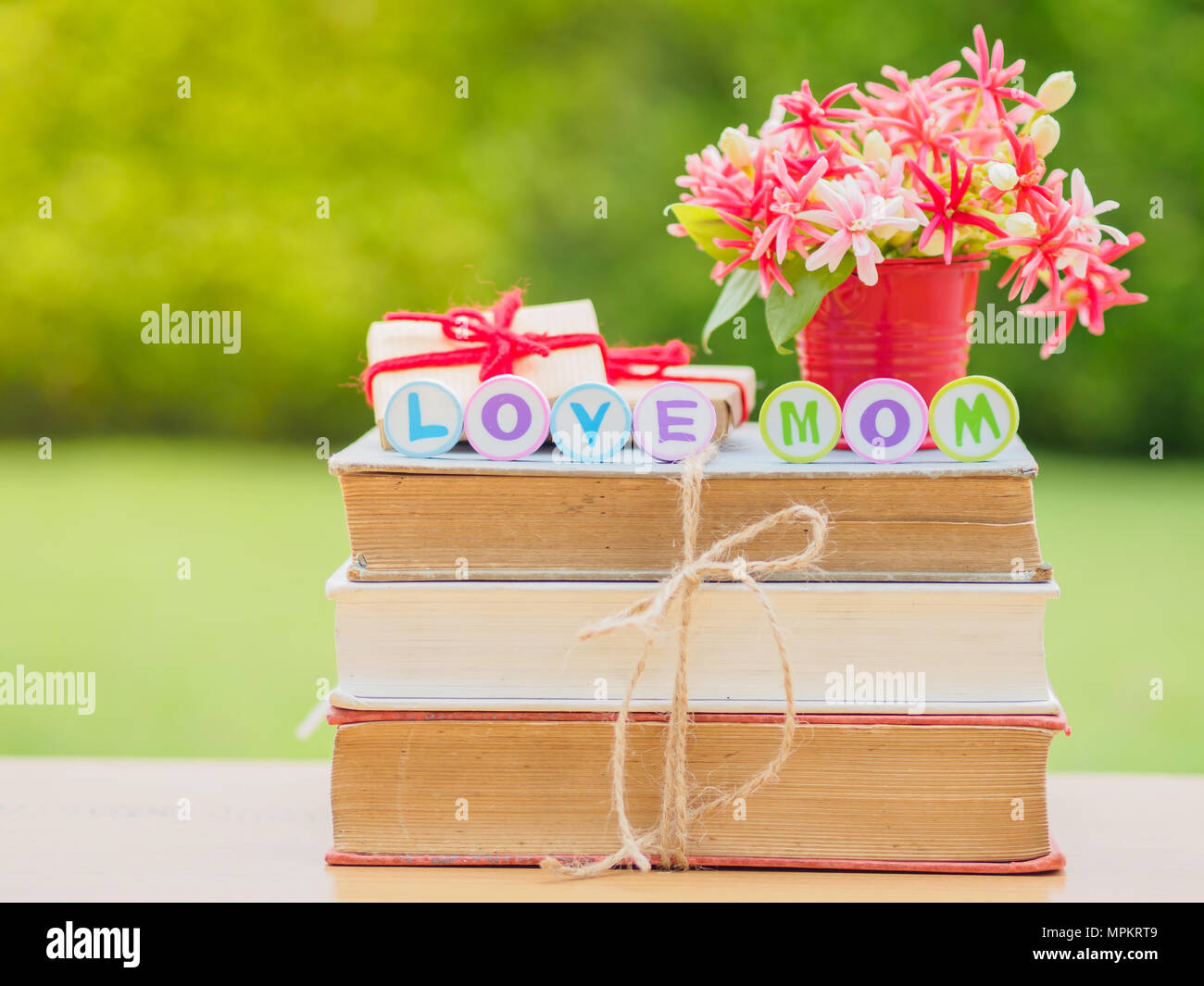 mother's day concept. LOVE MOM alphabet on stack of books, gifts, tea ...