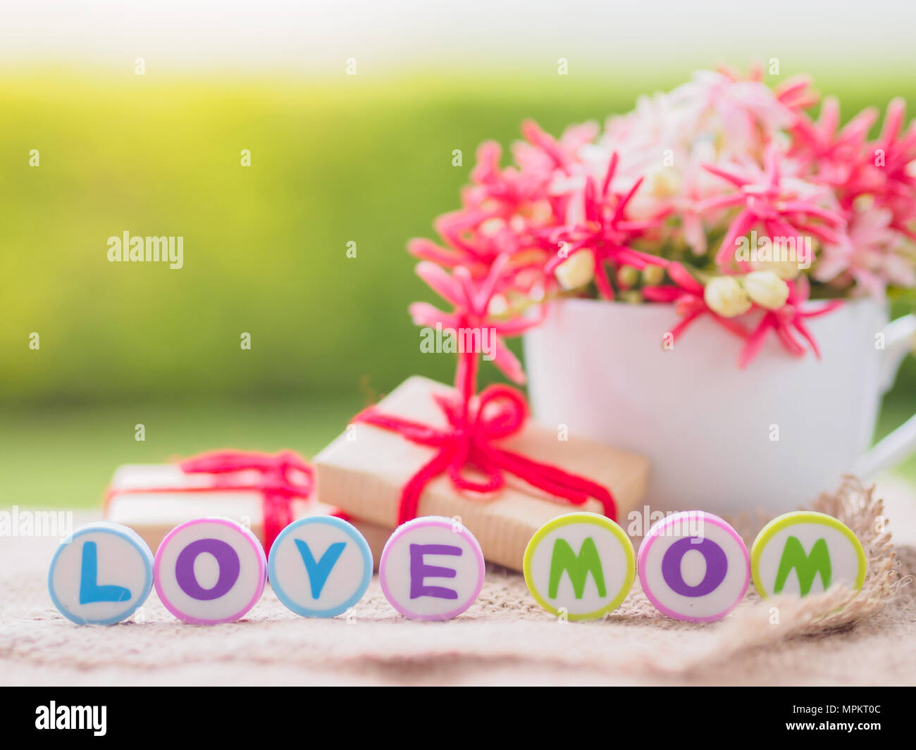 mother's day concept. LOVE MOM alphabet with gift and flower on ...