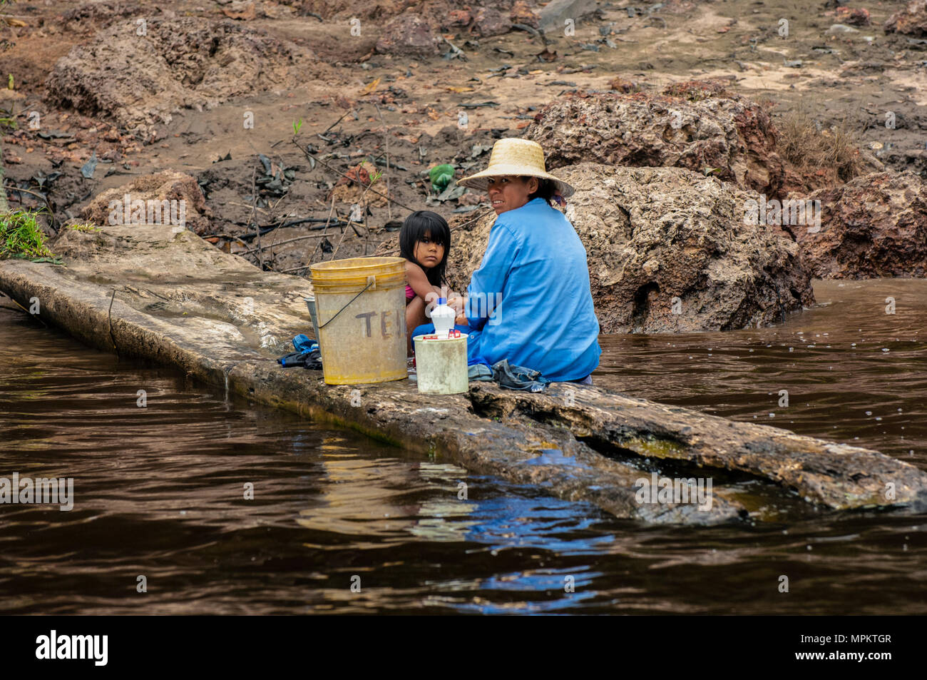 Mother and daughter doing laundry in the water of the Amazon River ...