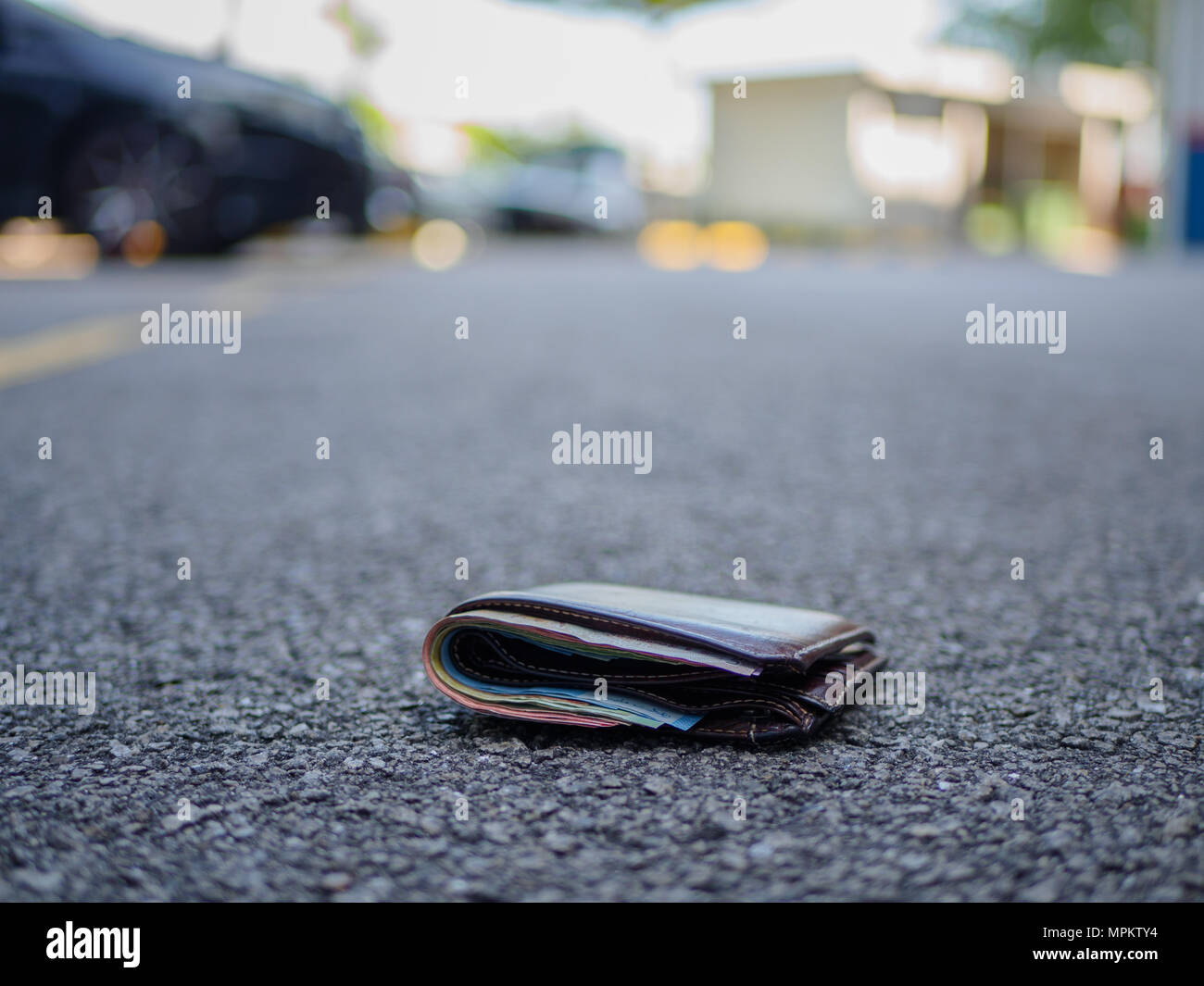 wallet with money drop on the street, lost money concept, copy space on ...